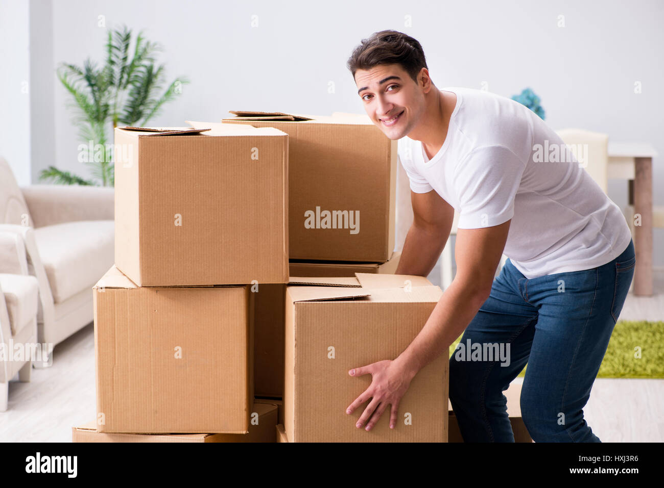 Young man moving boxes at home Stock Photo - Alamy