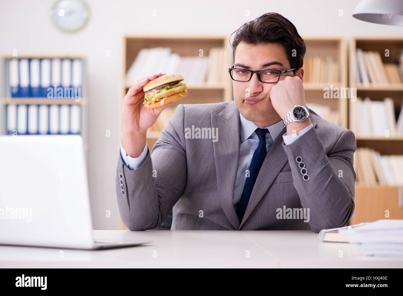 Hungry funny businessman eating junk food sandwich Stock Photo - Alamy