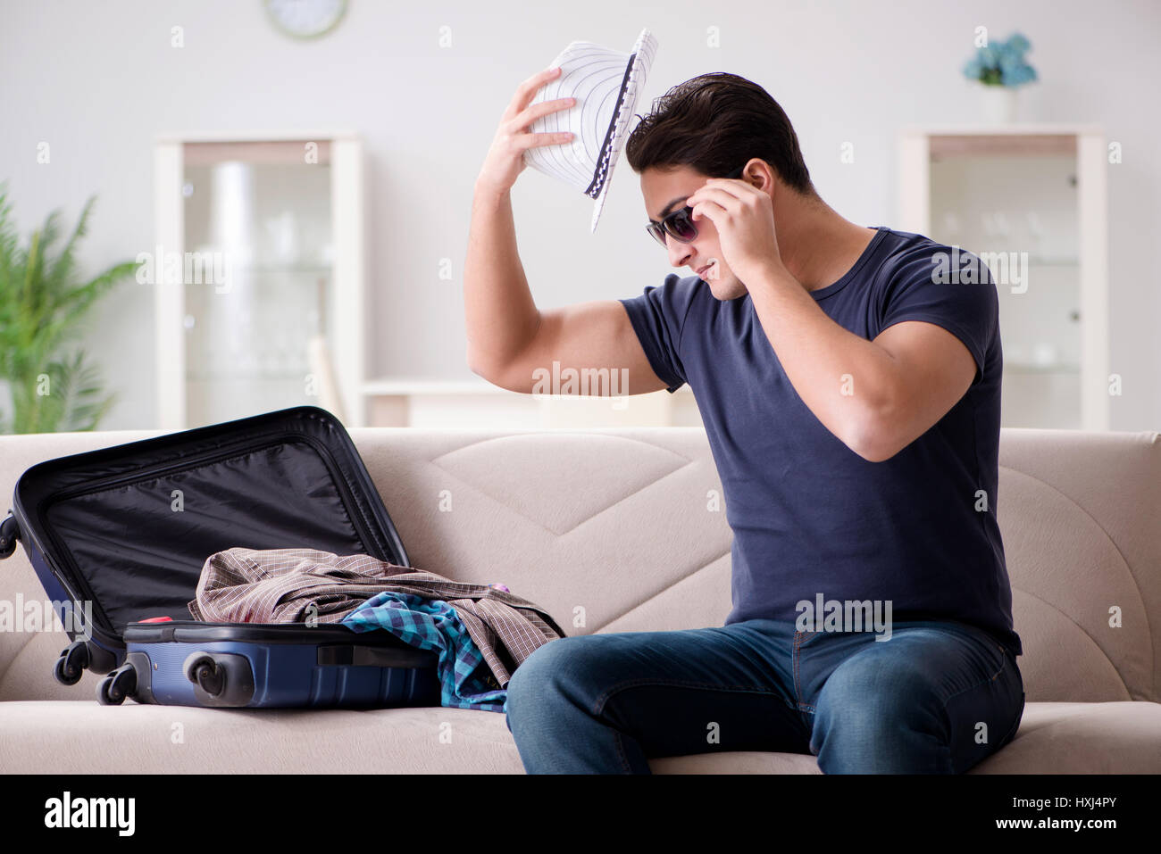 Man going on vacation packing his suitcase Stock Photo - Alamy
