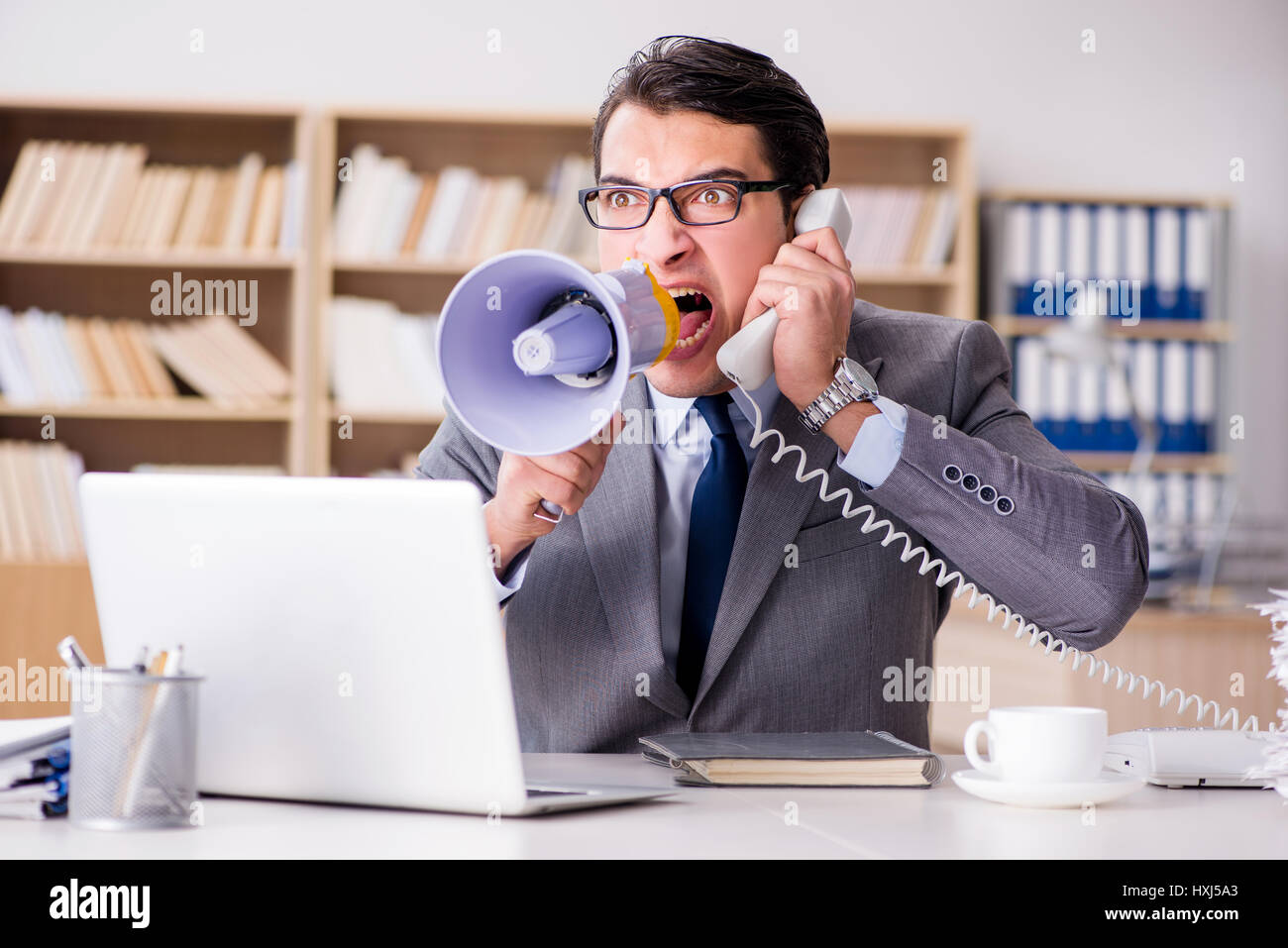 Angry businessman with too much work in office Stock Photo - Alamy