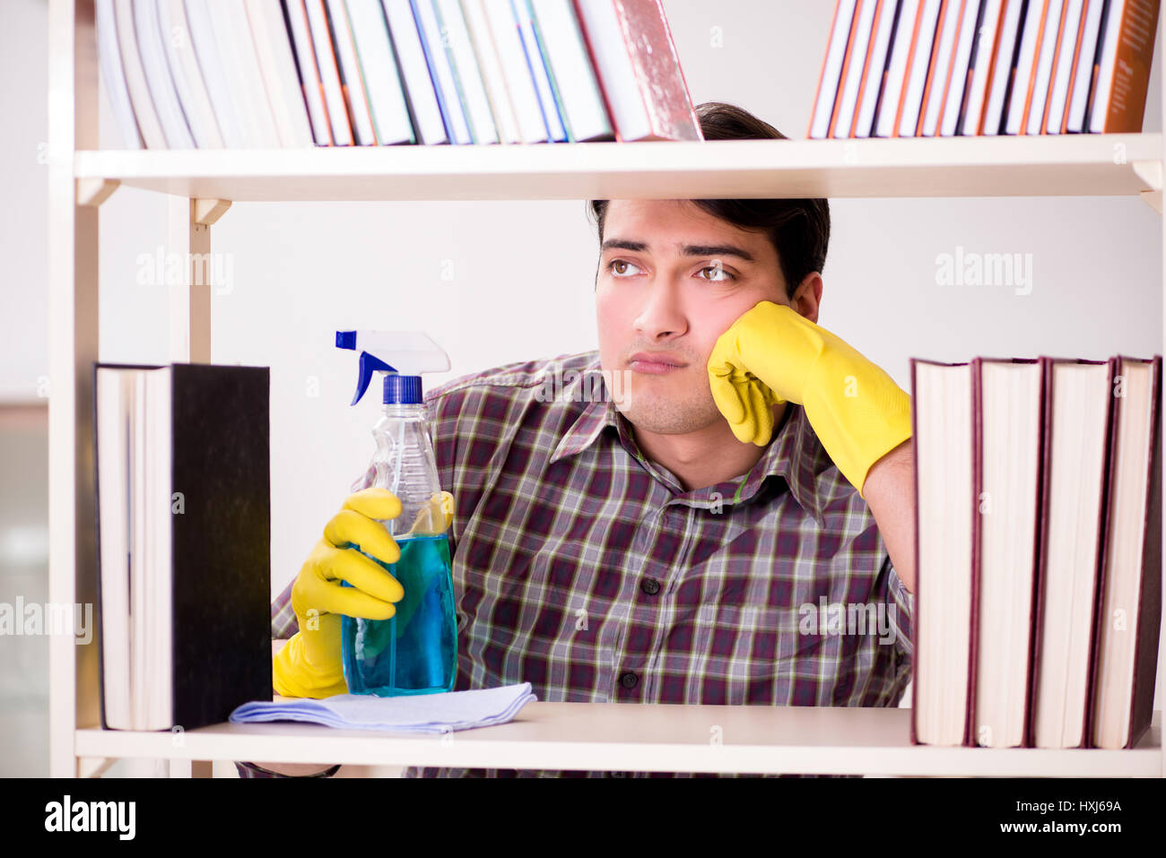 Man cleaning dust from bookshelf Stock Photo - Alamy