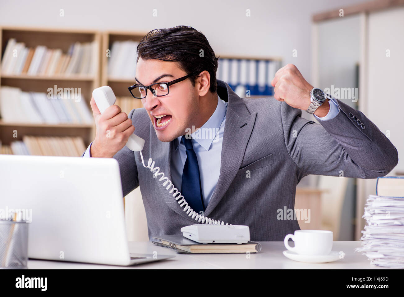 Angry businessman with too much work in office Stock Photo - Alamy