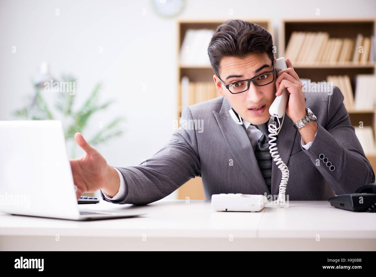 Helpdesk operator talking on phone in office Stock Photo - Alamy