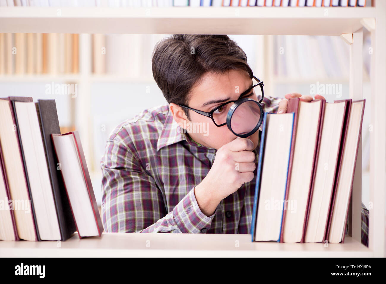Young student looking for books in college library Stock Photo - Alamy