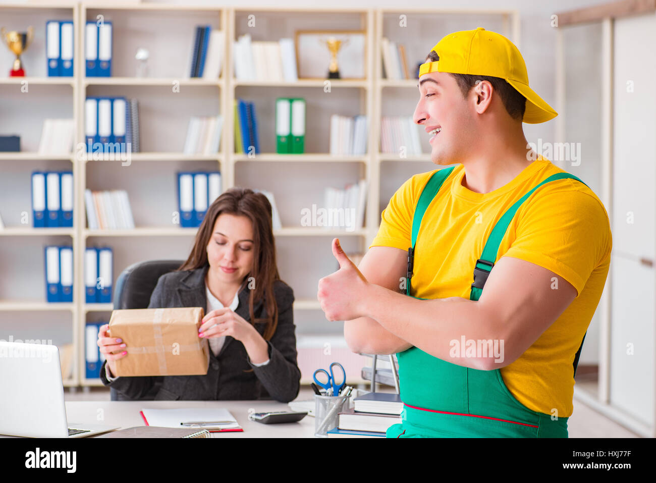 Postman delivering parcel to the office Stock Photo - Alamy