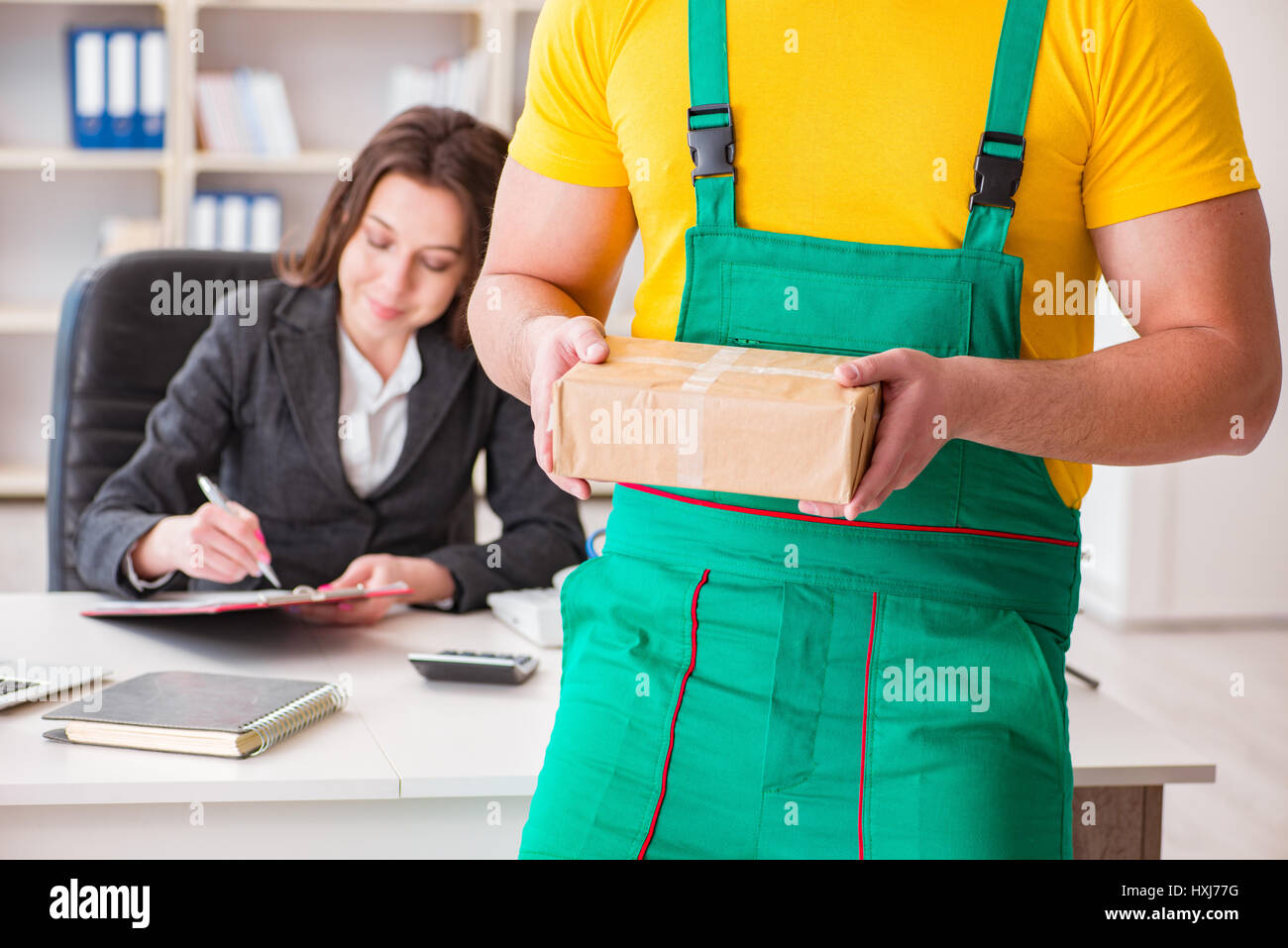 Postman delivering parcel to the office Stock Photo - Alamy