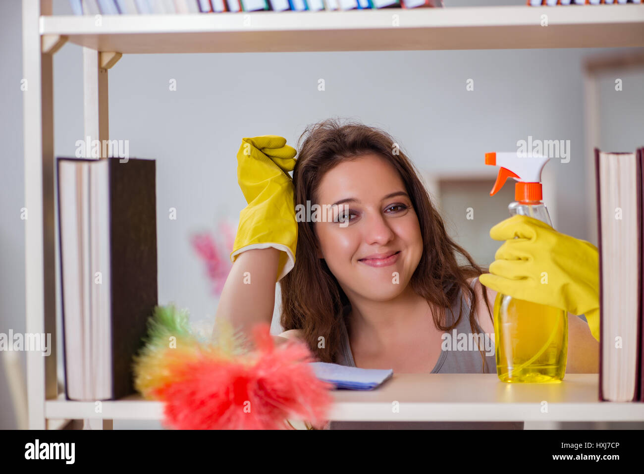 Woman cleaning dust from bookshelf Stock Photo - Alamy