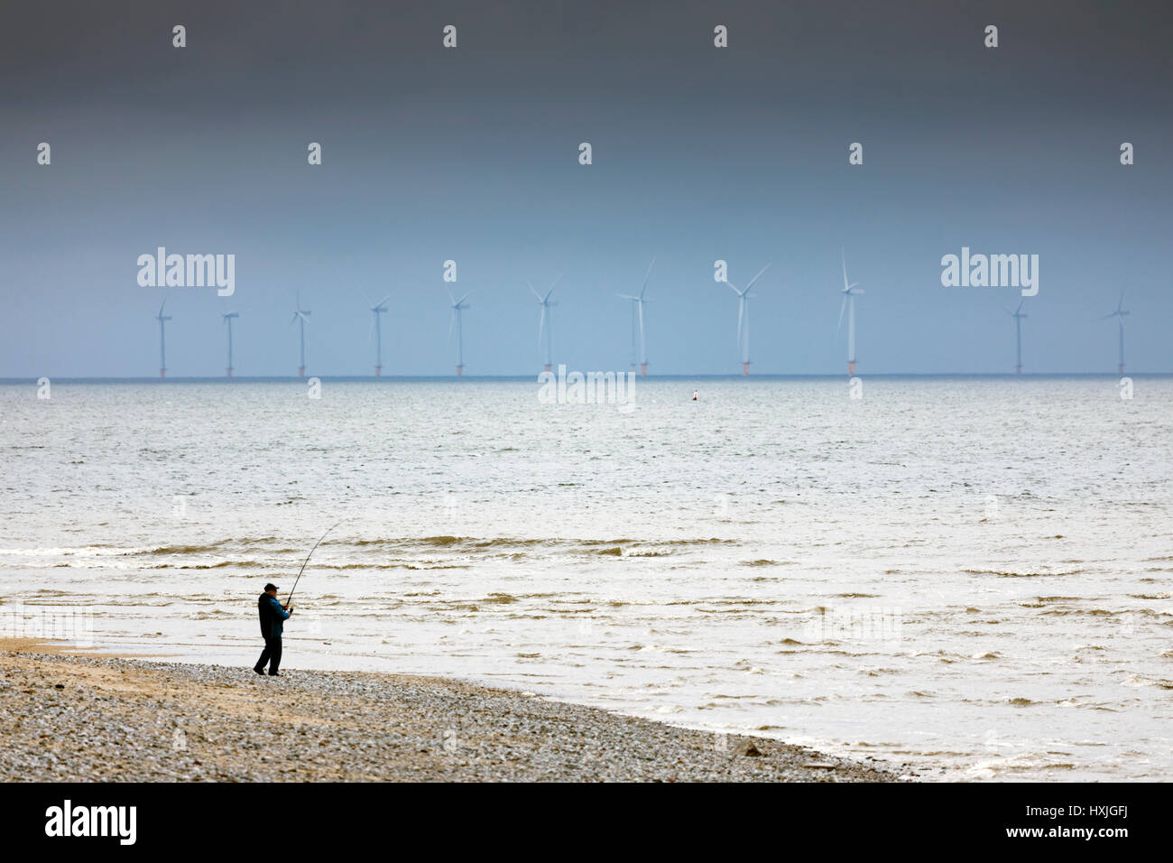 Man fishing alone along the shoreline of the popular tourist town of ...