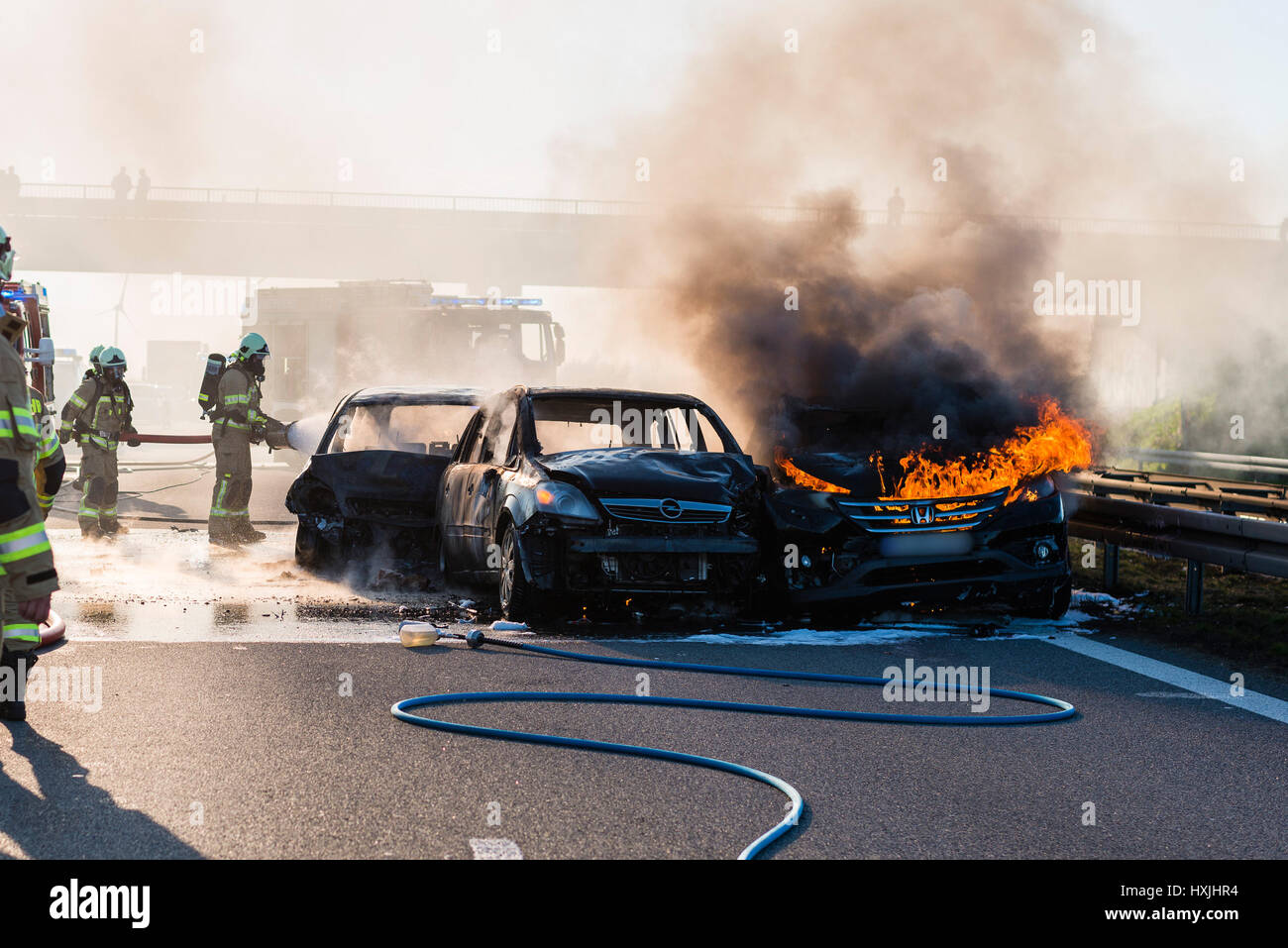 Members of a local fire brigade extinguish fires in three separate cars ...