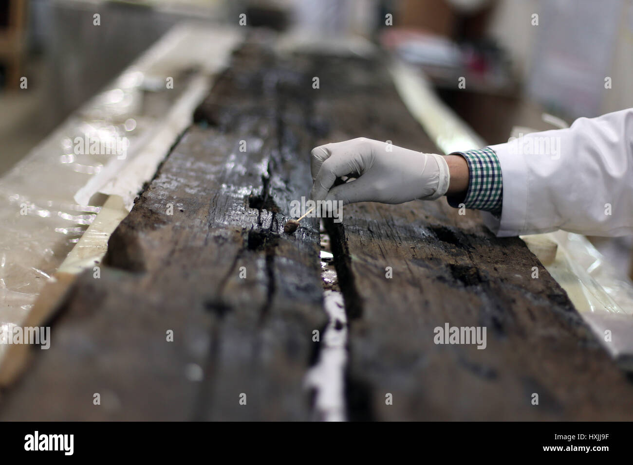 Giza, Egypt. 29th March 2017. An archaeologist works on parts of the ...