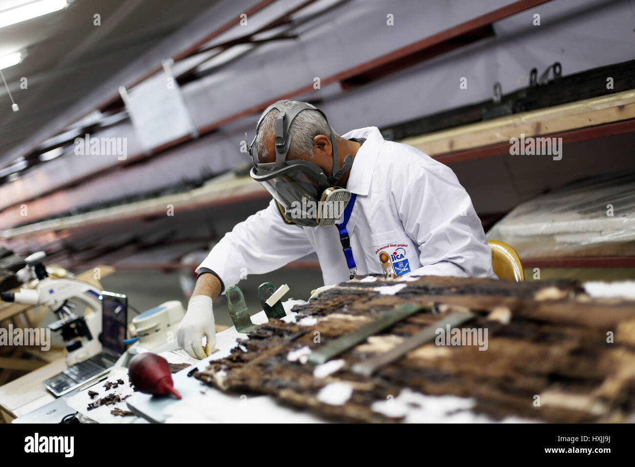Giza, Egypt. 29th March 2017. An archaeologist works on parts of the ...