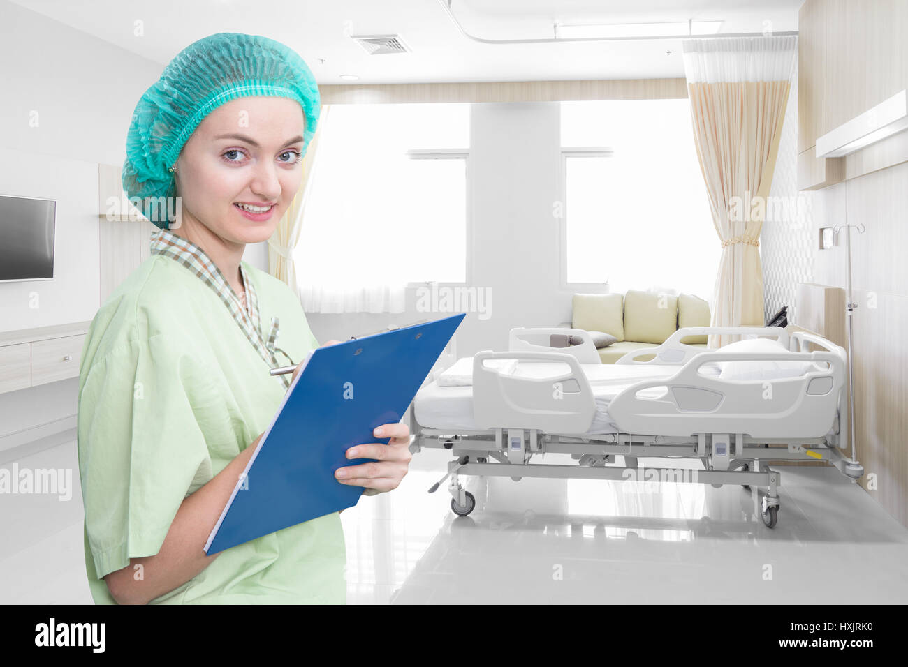Nurse writing medical records in modern hospital room with beds and ...