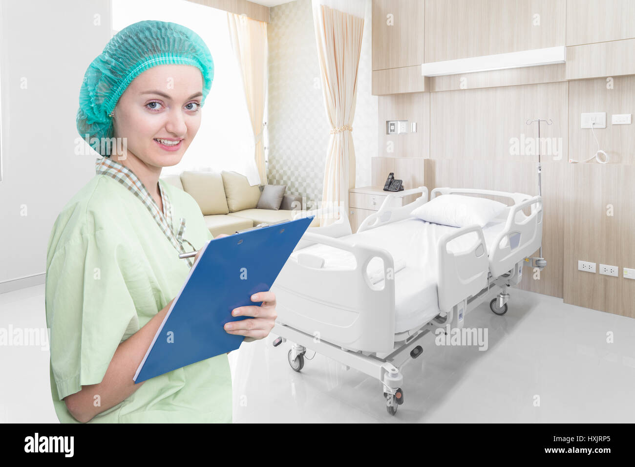 Nurse writing medical records in modern hospital room with beds and ...