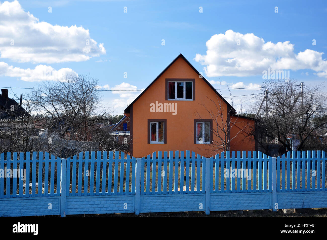 Orange house with blue fence Stock Photo - Alamy
