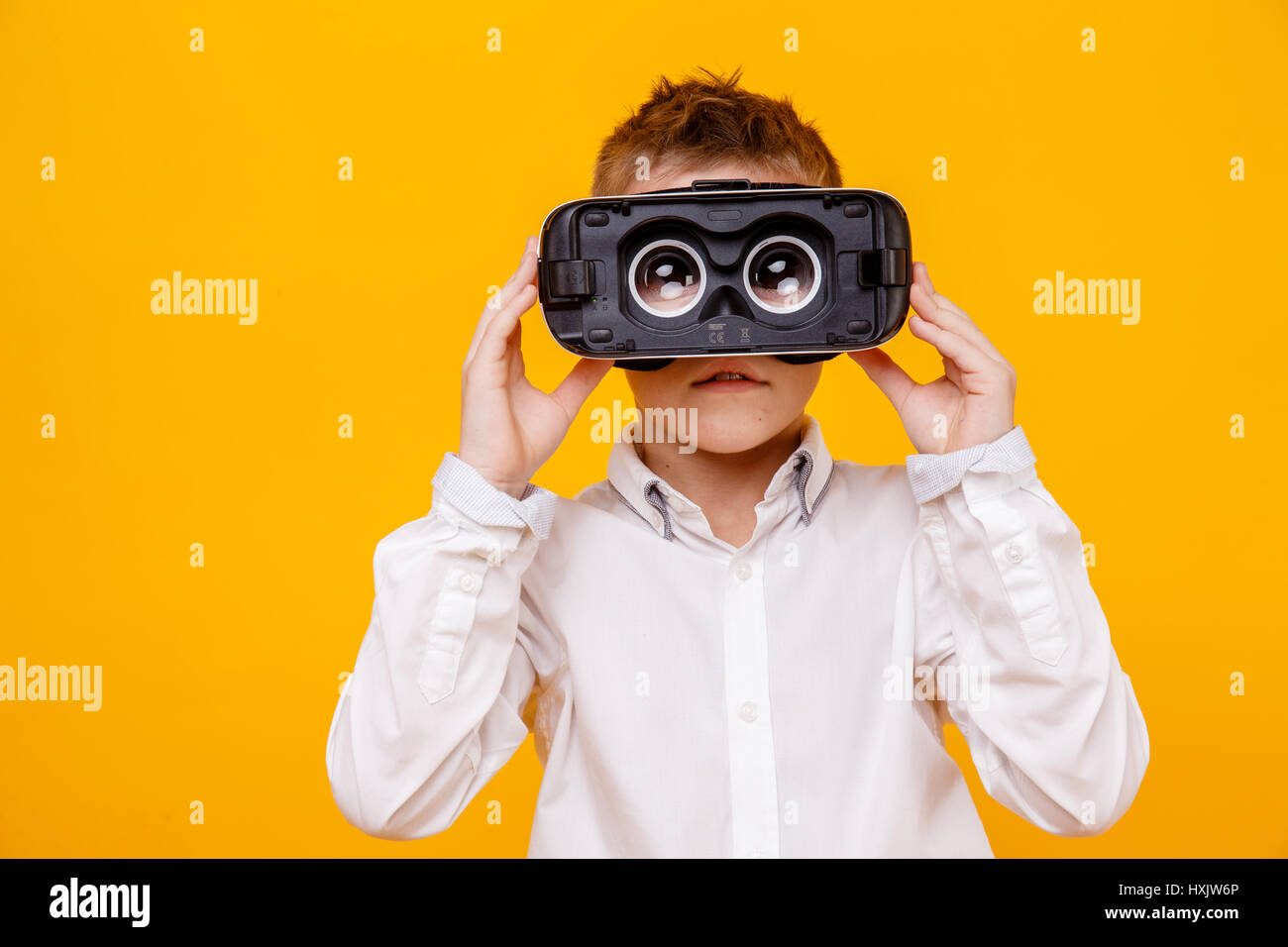 Kid looking at camera through VR glasses Stock Photo - Alamy