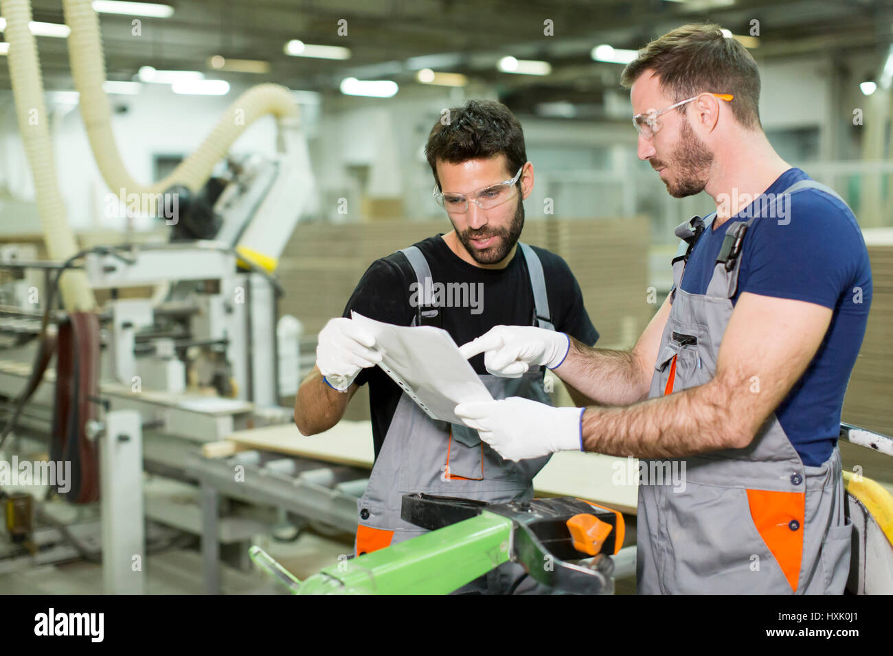 Two handsome young men working in lumber workshop Stock Photo - Alamy