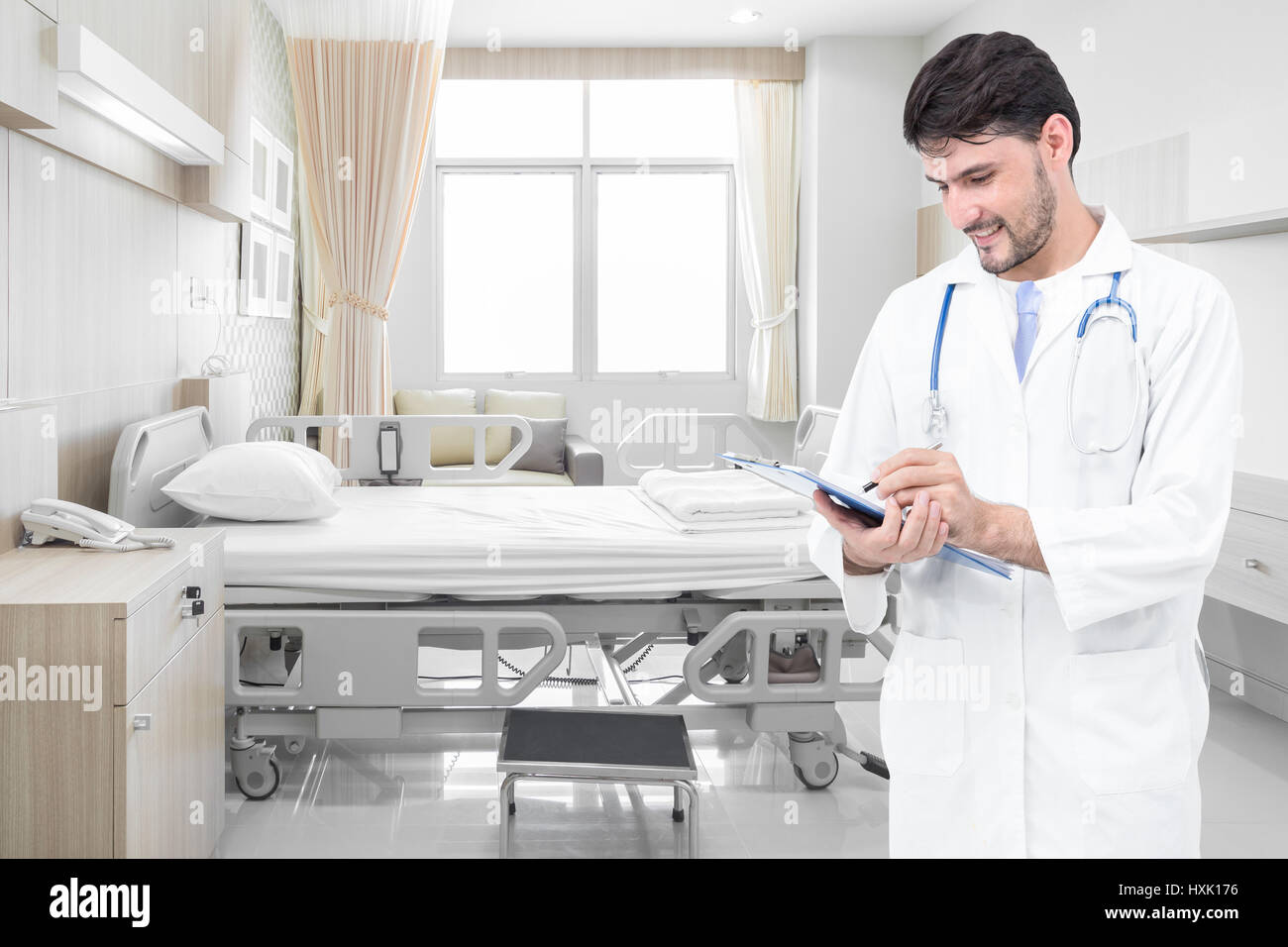 Doctor writing medical records in modern hospital room with beds and ...
