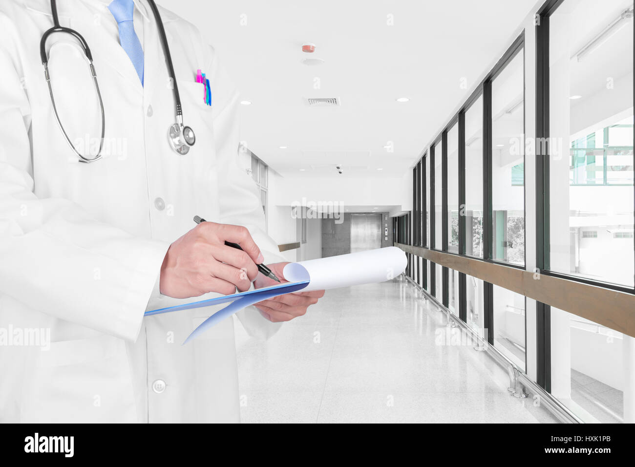 Doctor writing a medical prescription at new empty hospital hallway ...