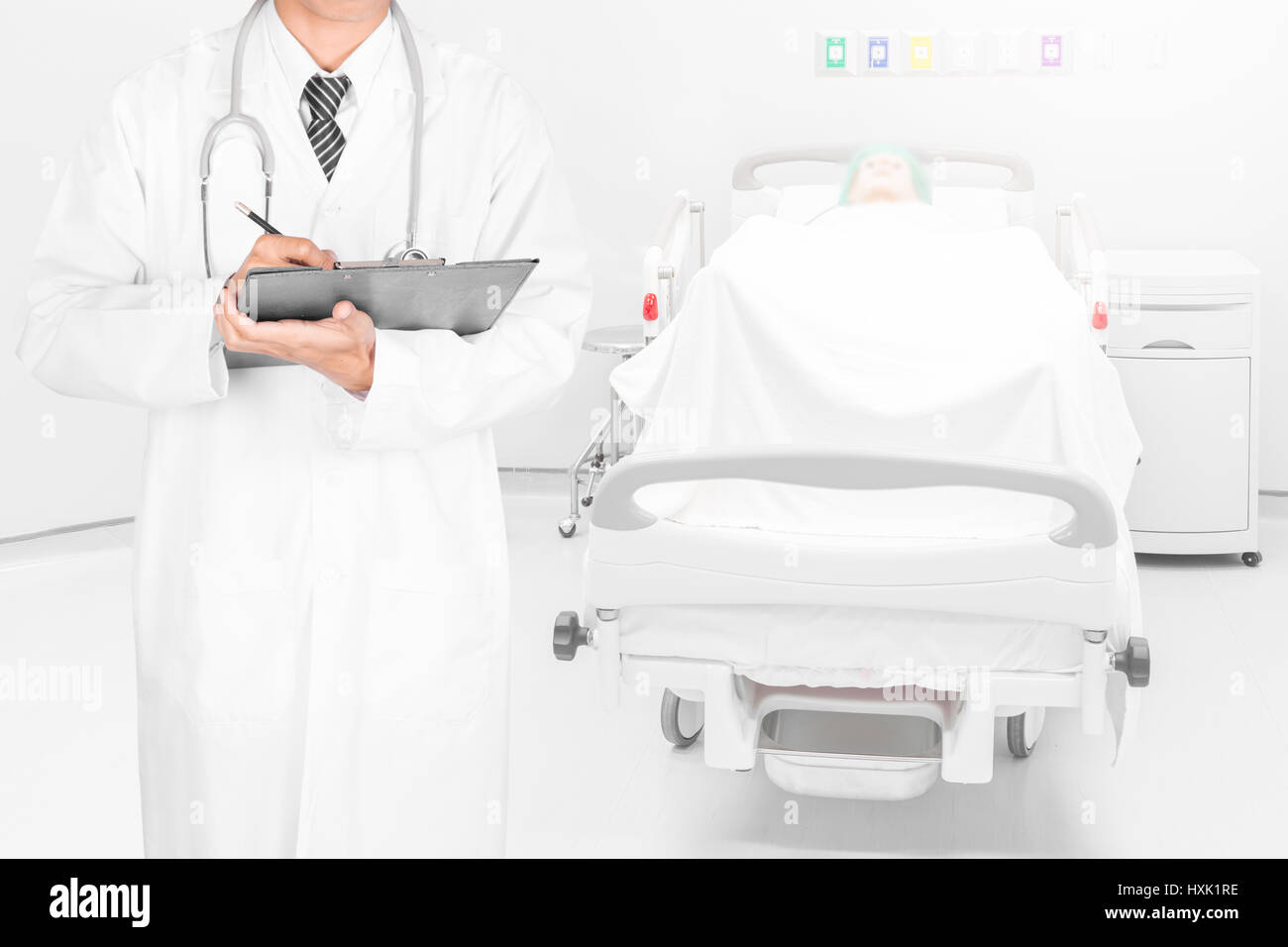 Doctor writing on a folder of diagnosis result in patient room Stock ...