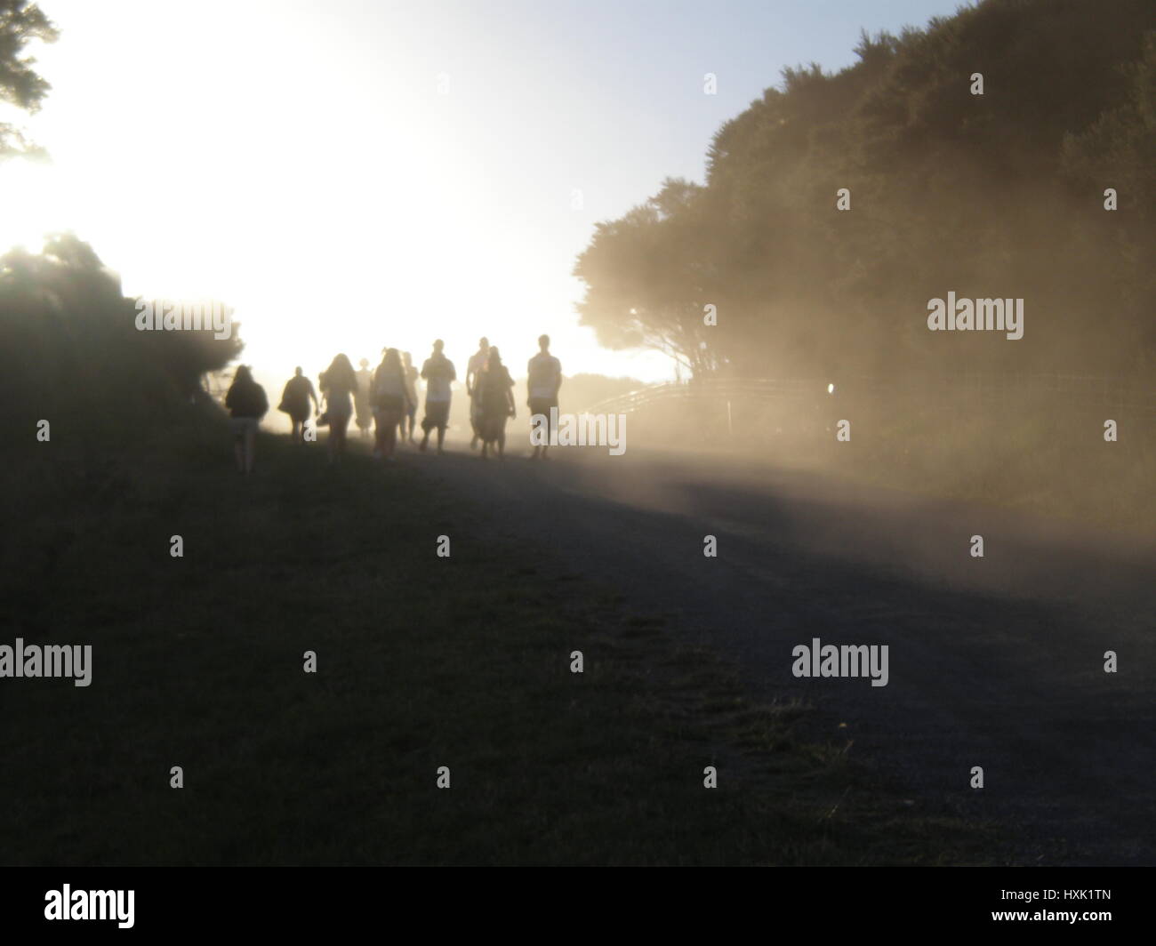 Silhouette of group of people in the landscape walking into the light ...