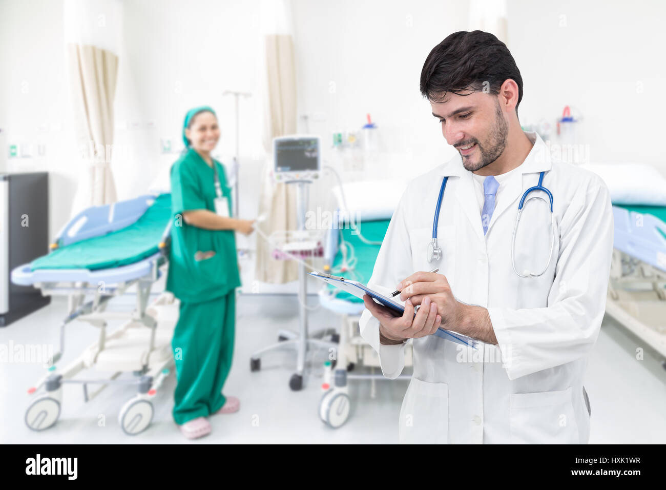 Doctor writing medical records in modern hospital room with beds and ...