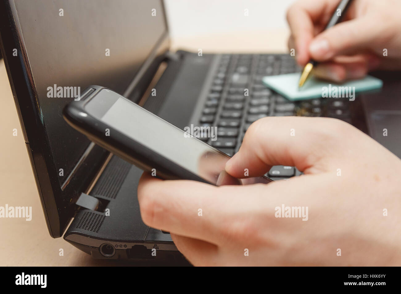 Note taking while use smartphone and laptop computer Stock Photo - Alamy
