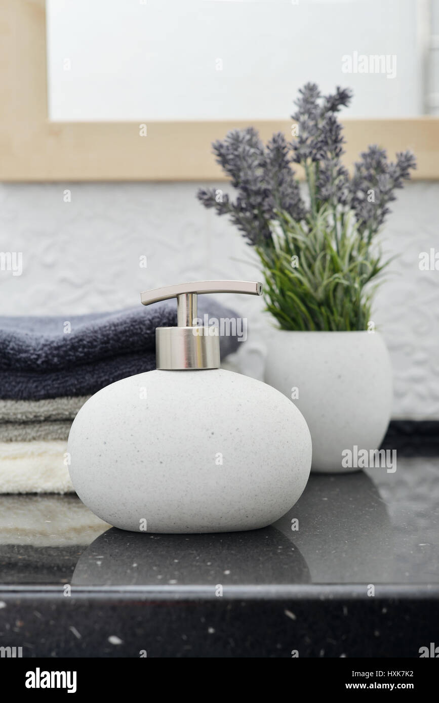 Soap dispenser with a stack of towels in a bathroom closeup Stock Photo ...