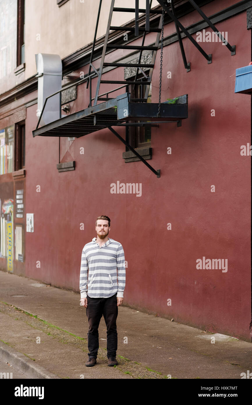 Hipster posing outdoors for the camera with a fashion forward style and ...