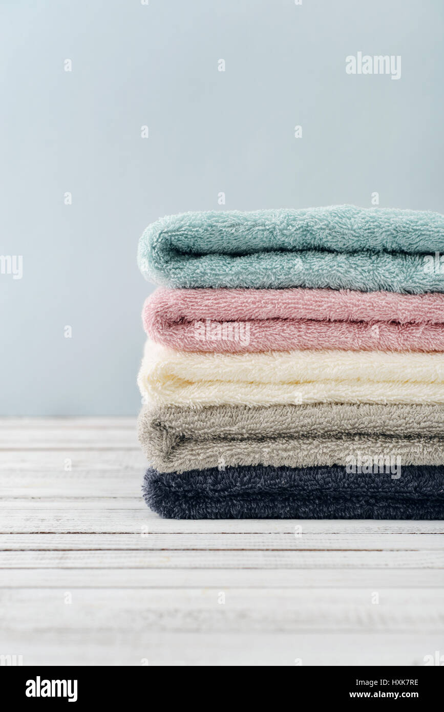 Stack of bath towels on light wooden background closeup Stock Photo - Alamy