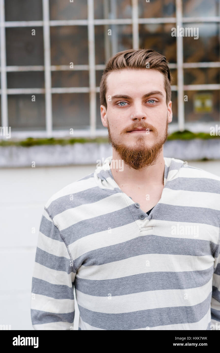 Hipster posing outdoors for the camera with a fashion forward style and ...
