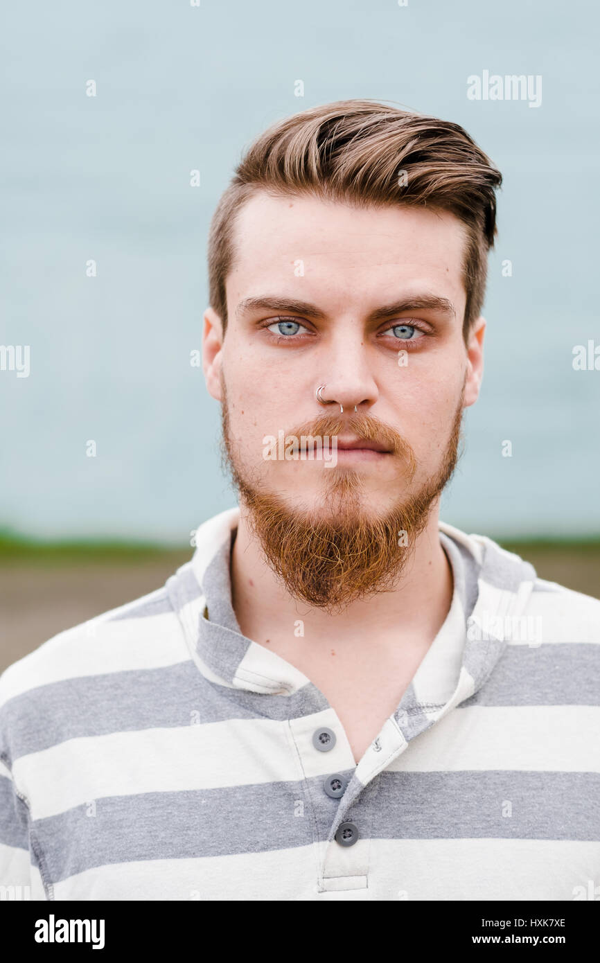 Hipster posing outdoors for the camera with a fashion forward style and ...