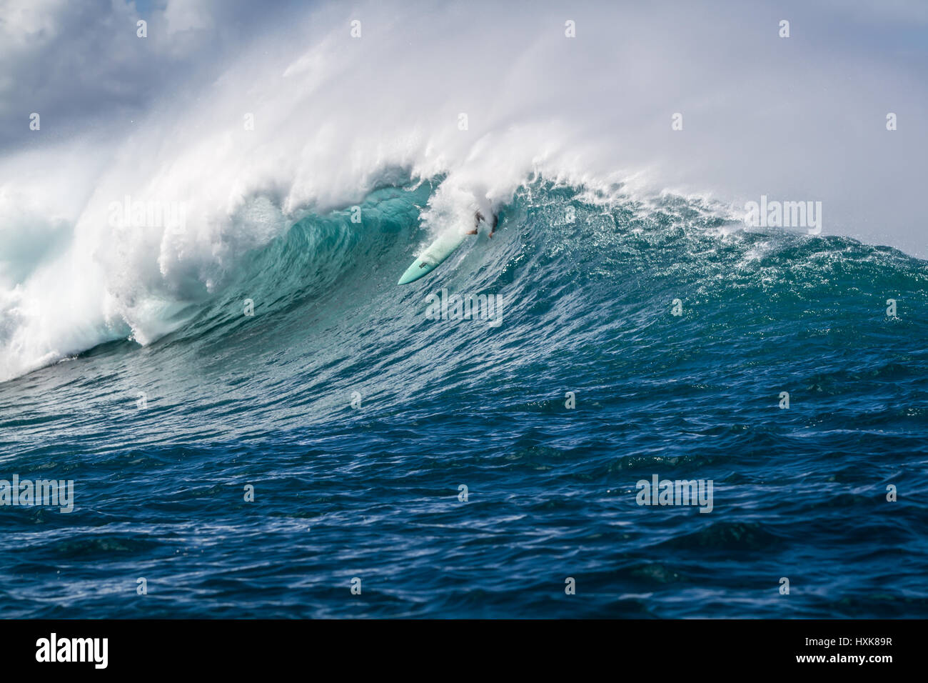 A surfer wipes out on a big Ocean wave on an outer reef surf break on ...