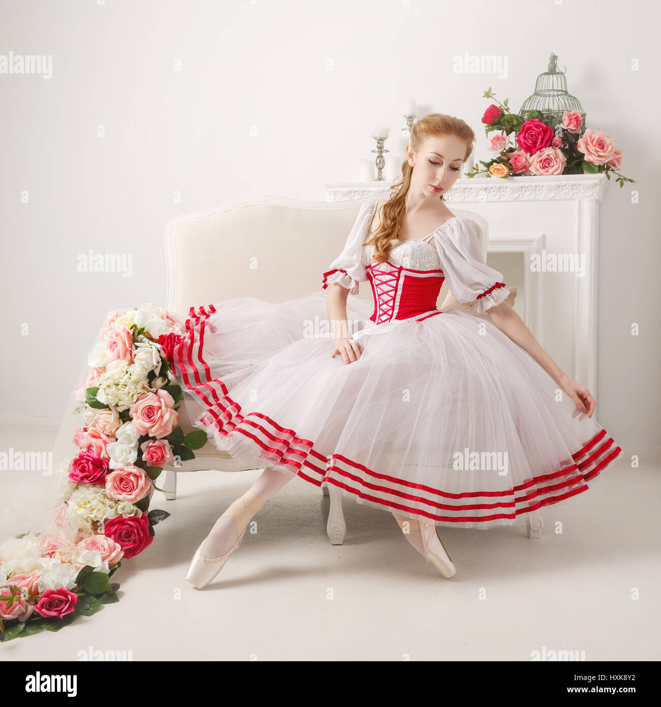 Sweet Ballerina In A Stage Suit Straightens Her Skirt Next To Bouquets