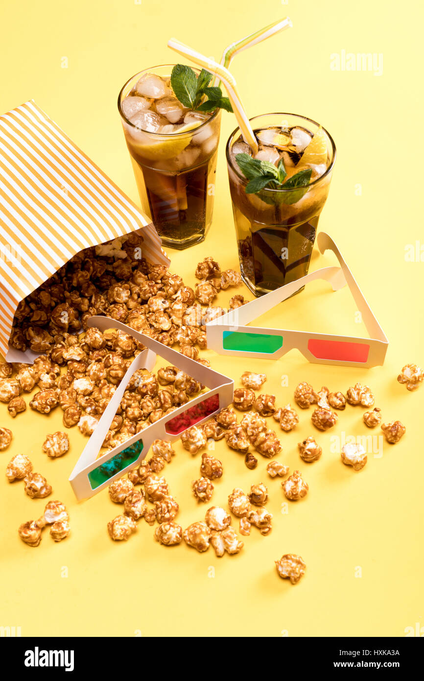 close up view of popcorn, iced tea and 3D glases on yellow, Movie time ...