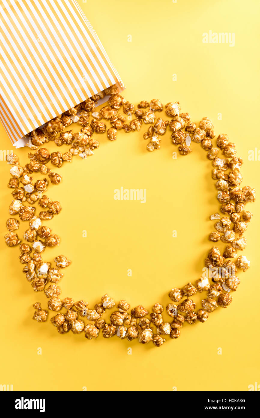 top view of circle made of popcorn and paper container on yellow Stock ...