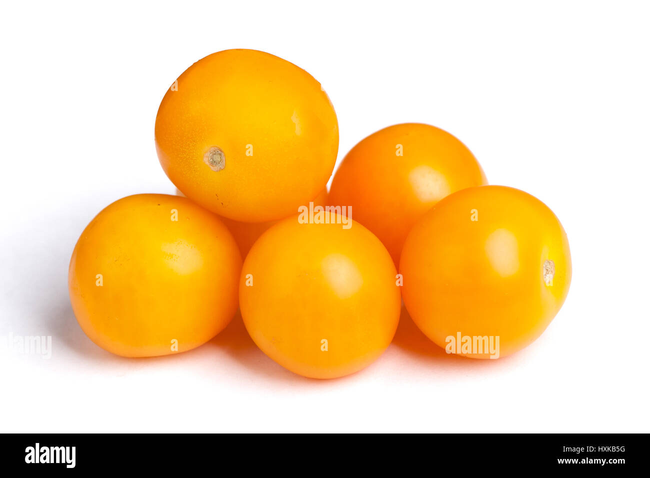 Heap of yellow tomatoes isolated on white background Stock Photo - Alamy