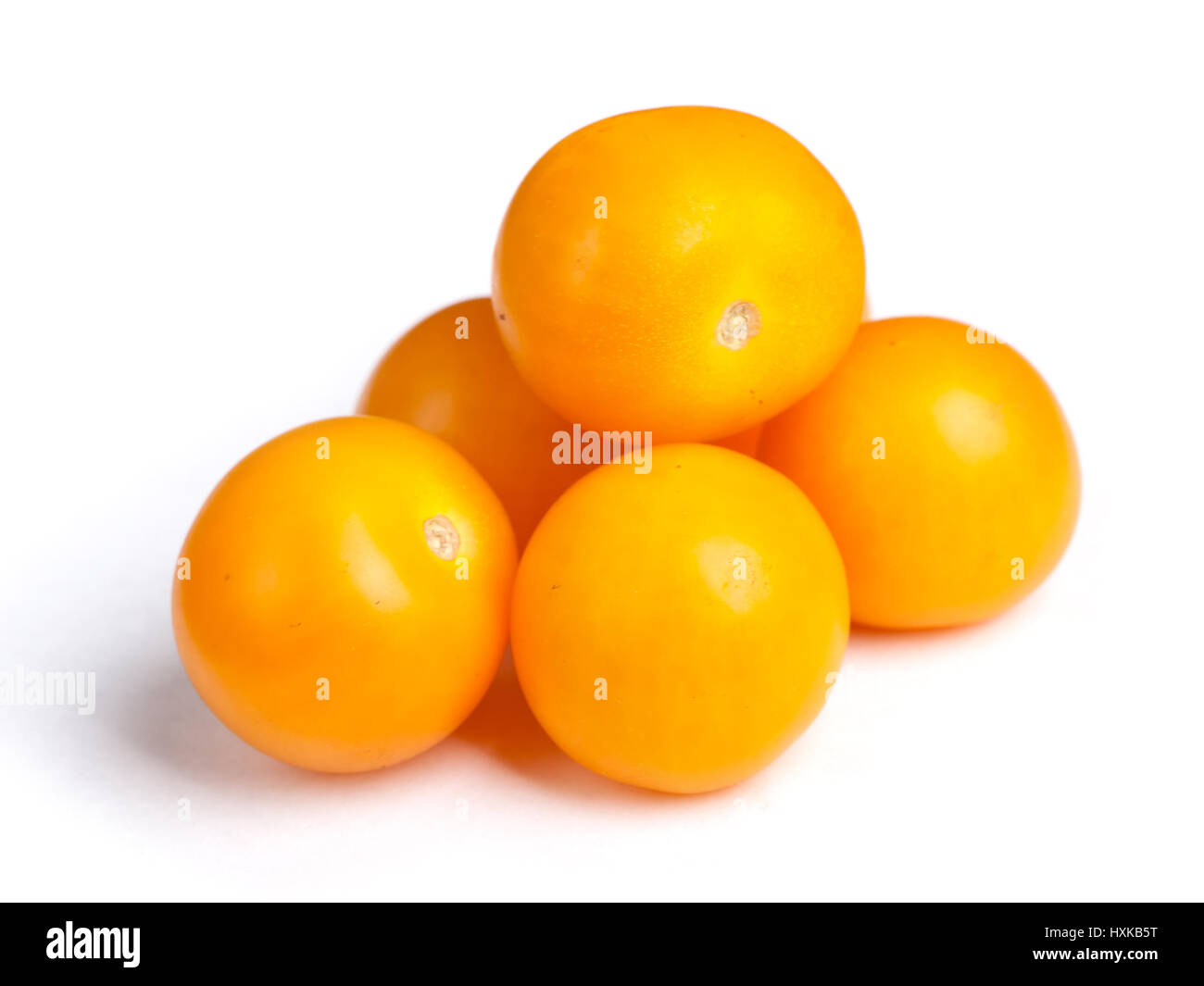Heap of yellow tomatoes isolated on white background Stock Photo - Alamy