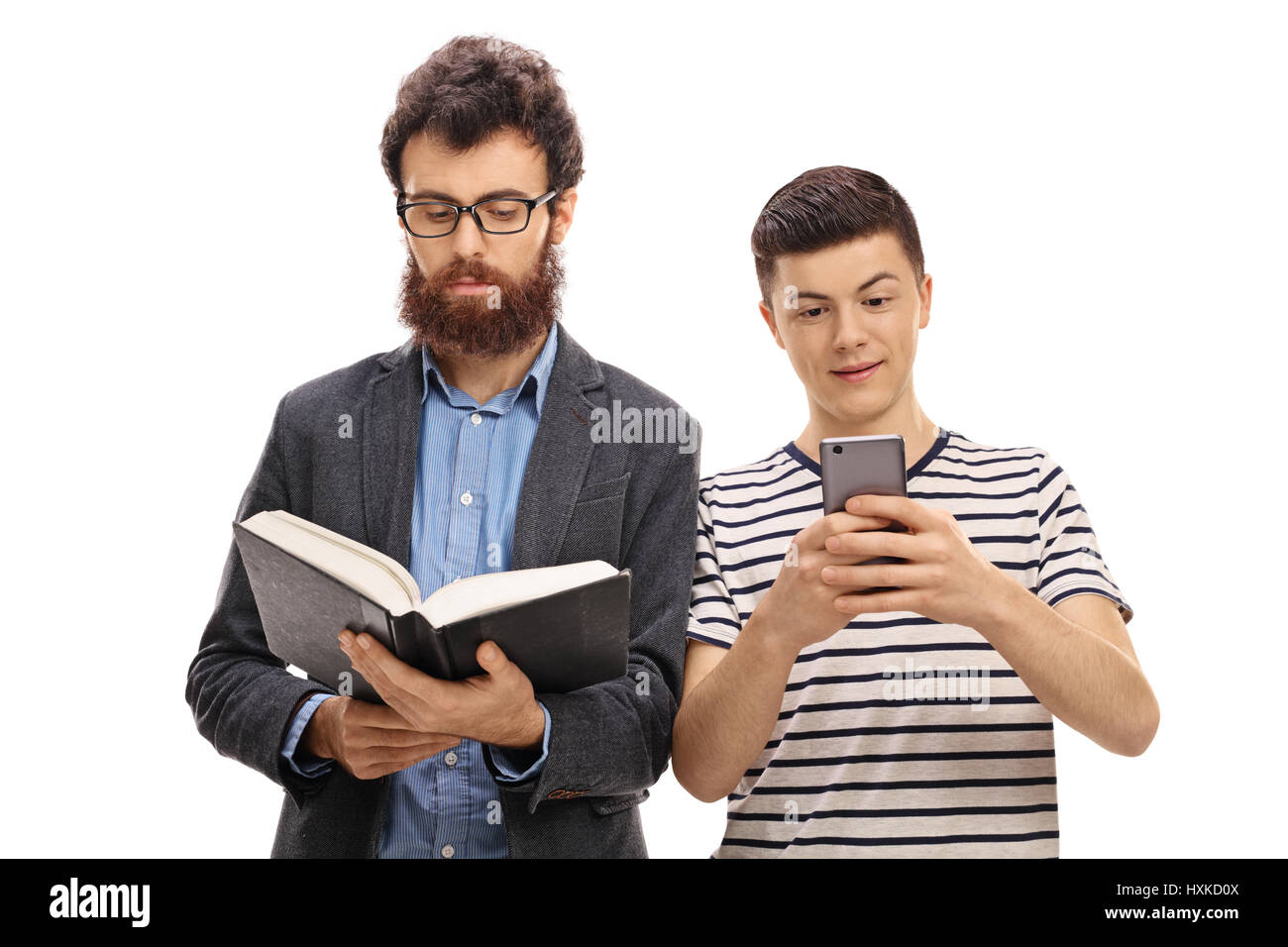 Young man reading a book with a teenage boy looking at a mobile phone ...