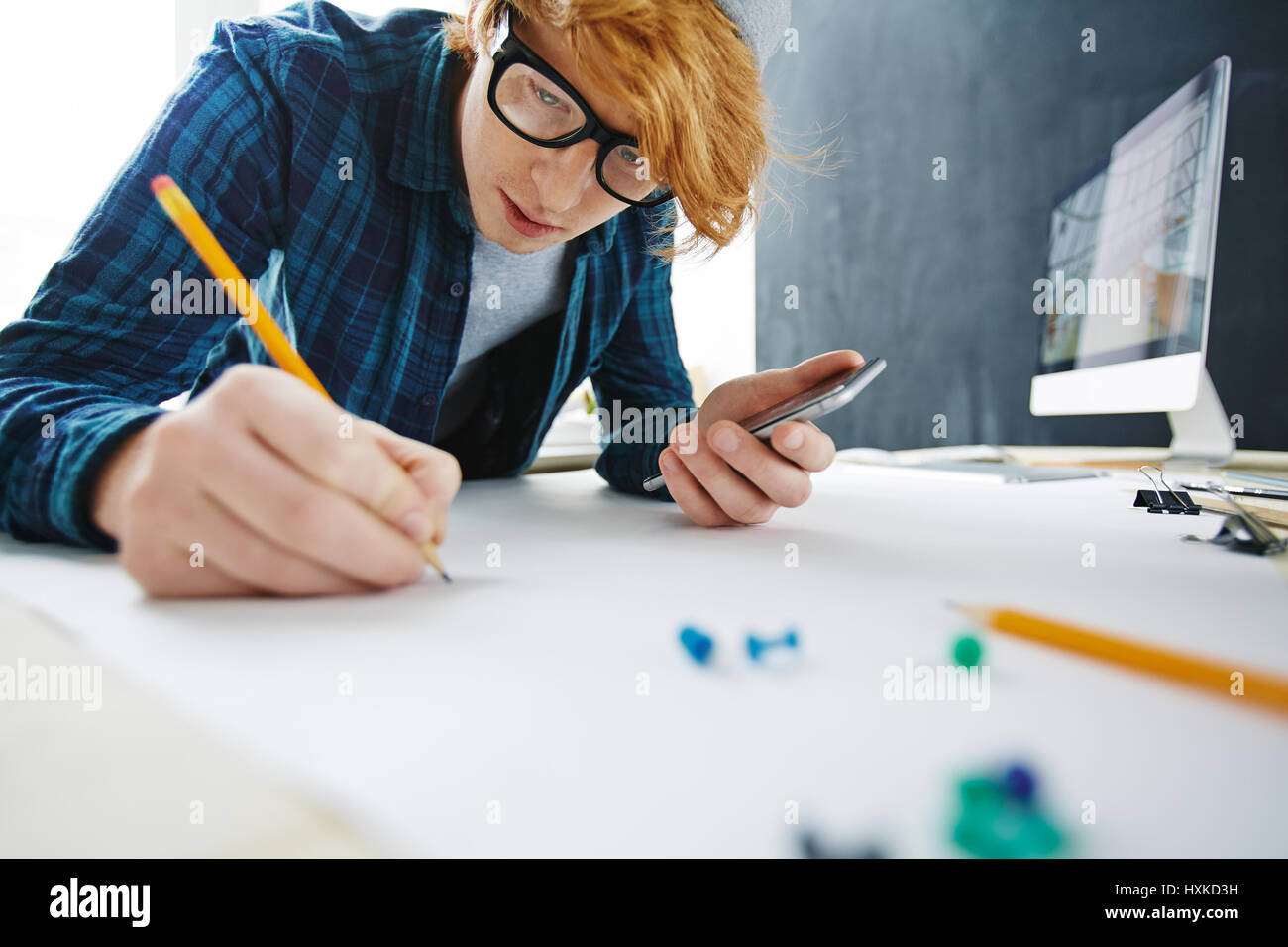 Creative red haired Man Drawing at Workplace Stock Photo - Alamy