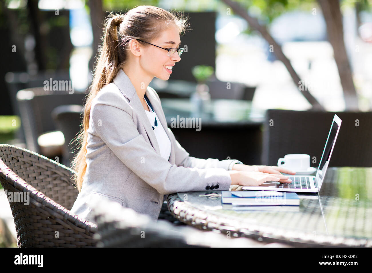 Using laptop in outdoor cafe Stock Photo - Alamy