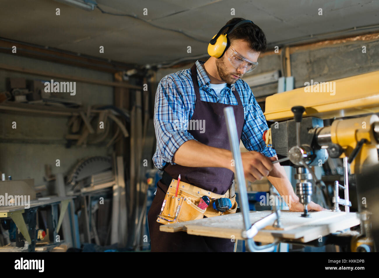 Bearded craftsman drilling work piece Stock Photo - Alamy