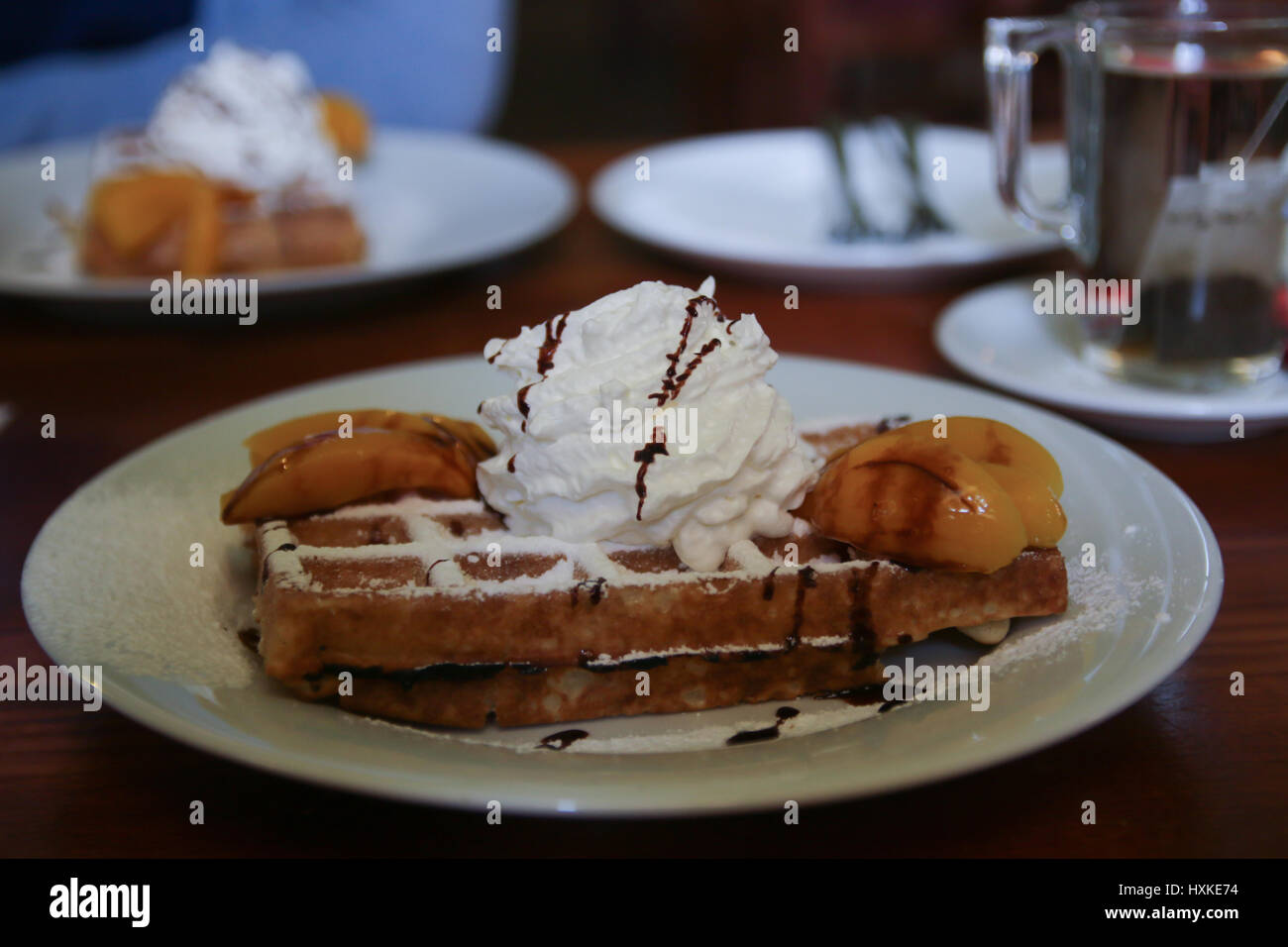 waffles with fruit and cream on wooden table in restaurant Stock Photo ...