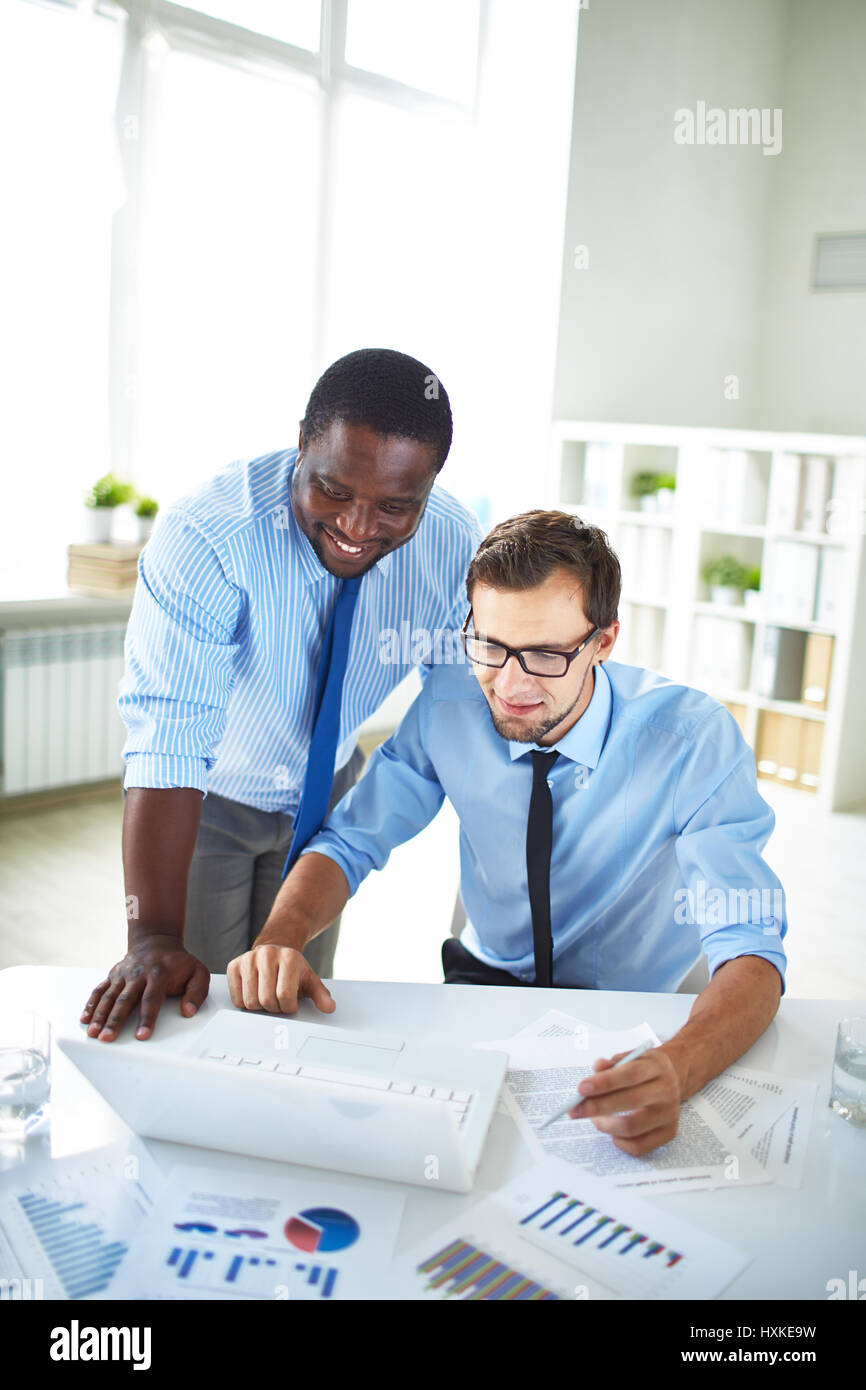 Explaining computer program to colleague Stock Photo - Alamy