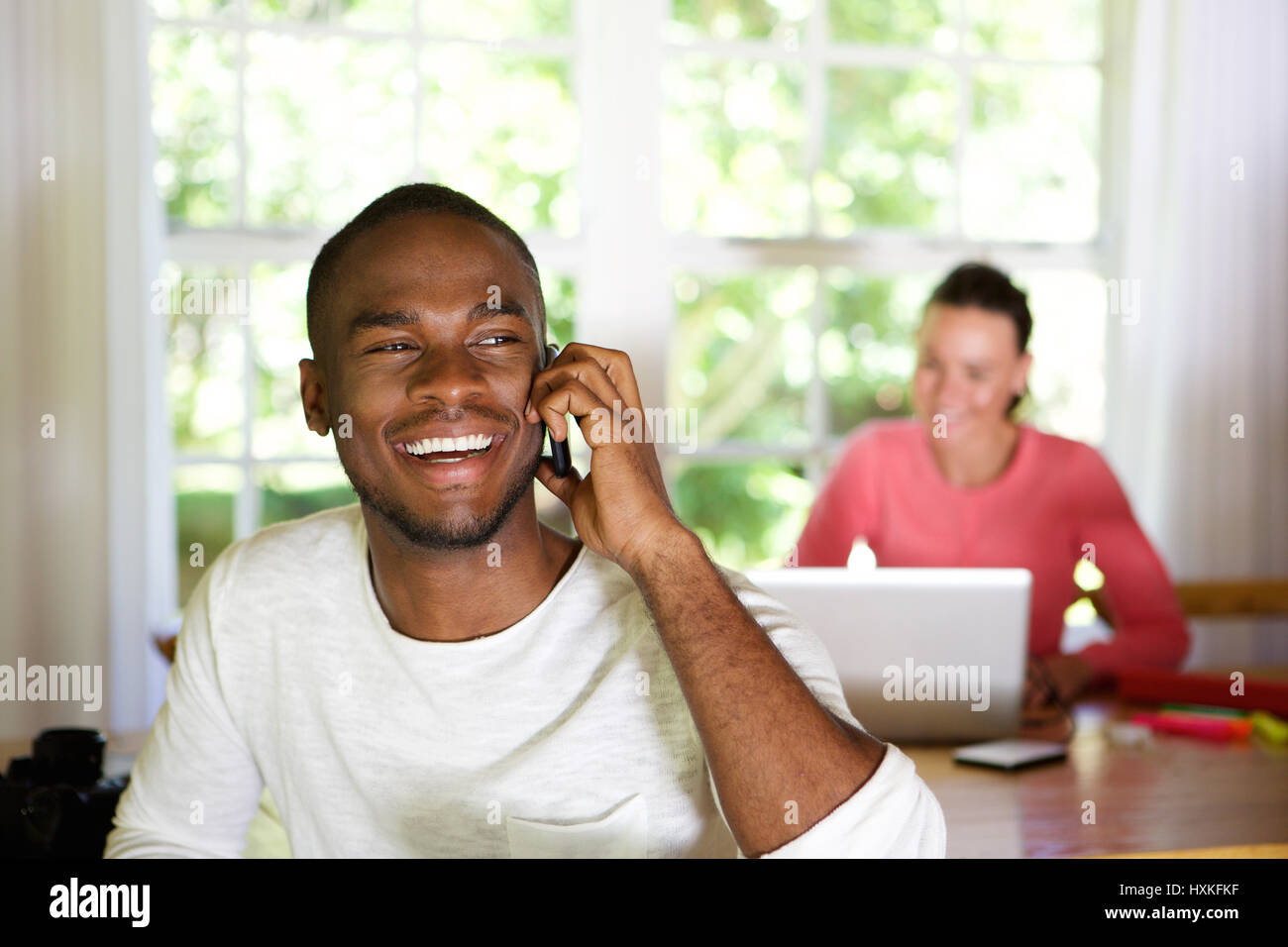 Close up portrait of smiling young african man talking on mobile phone ...