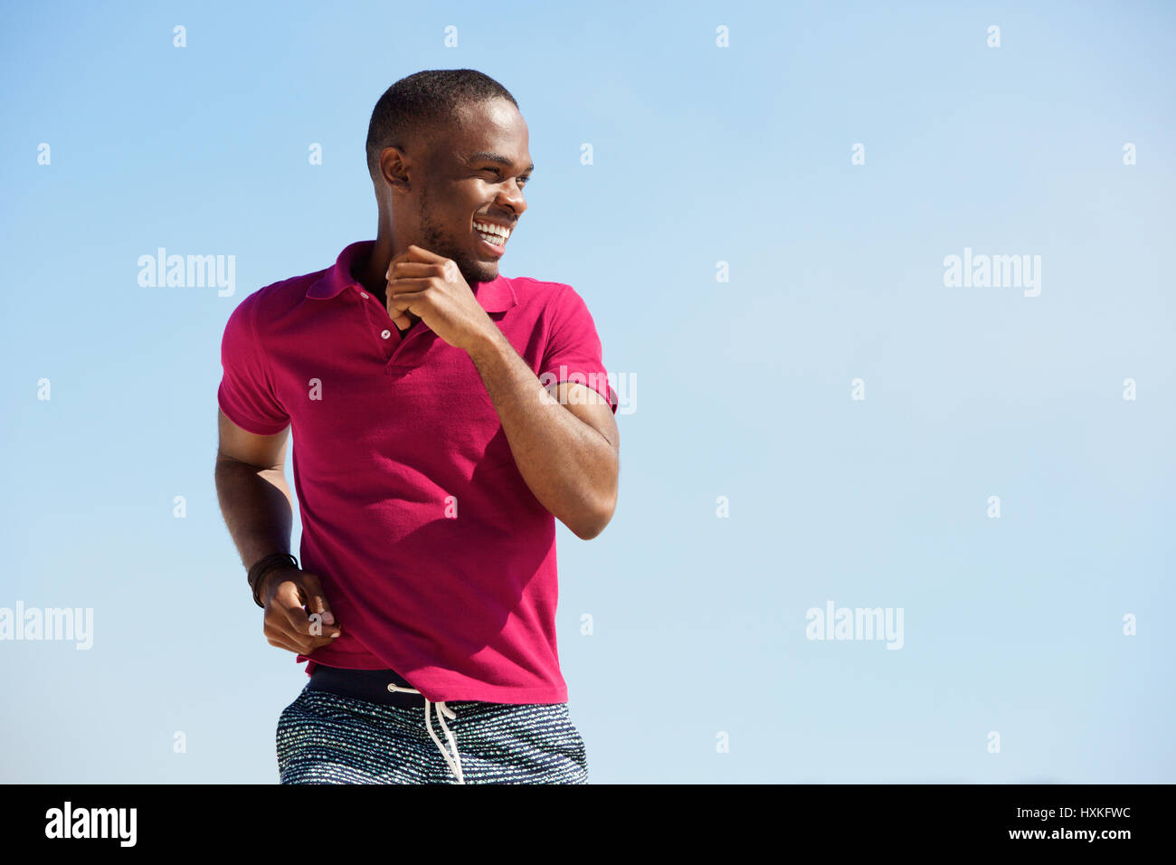 Portrait of healthy young african man running outdoors and smiling ...