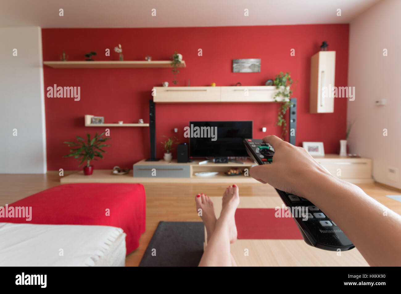 Using the remote controller of a tv in living room Stock Photo - Alamy