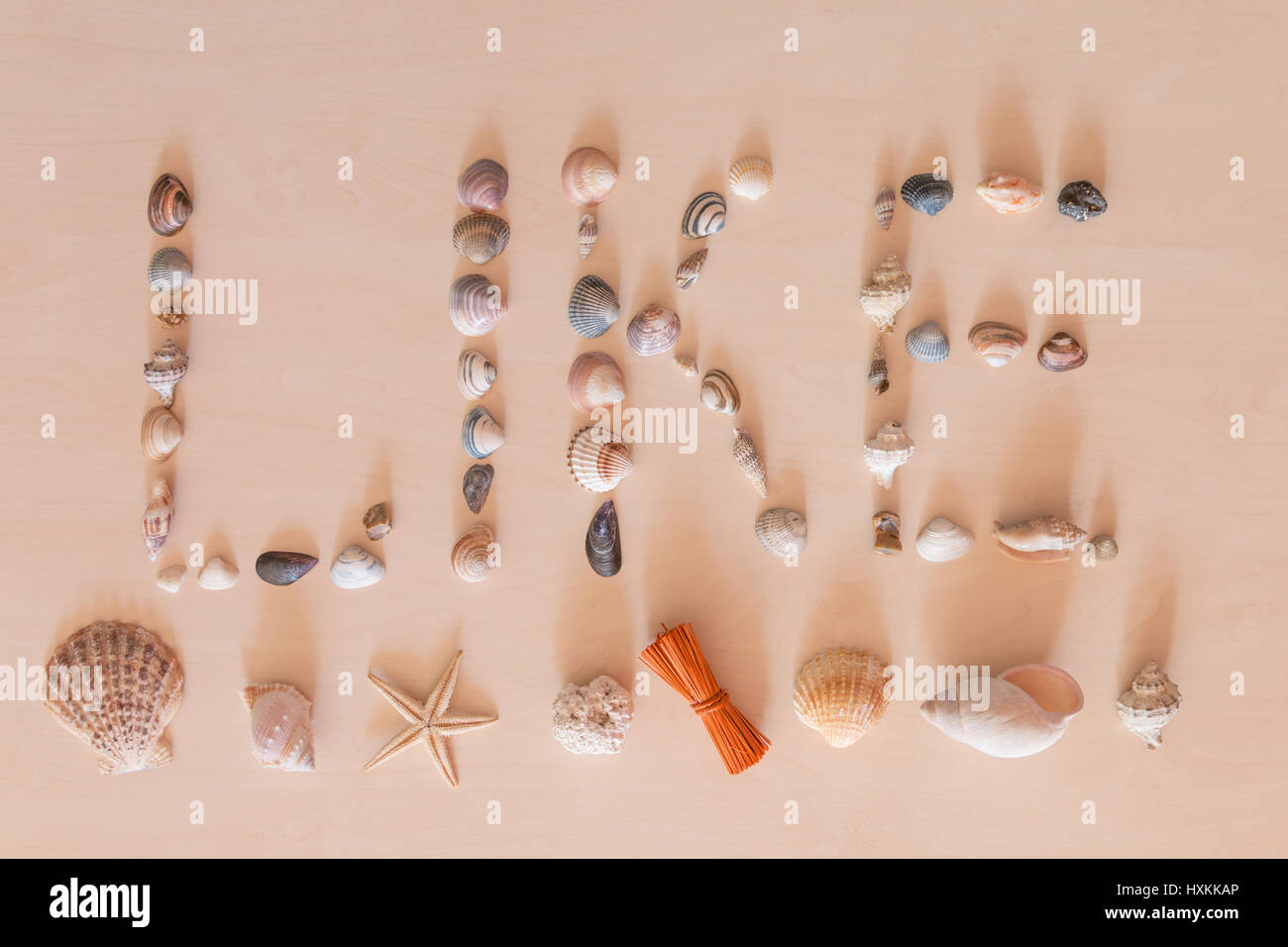LIKE words by sea shell on light wooden background Stock Photo - Alamy