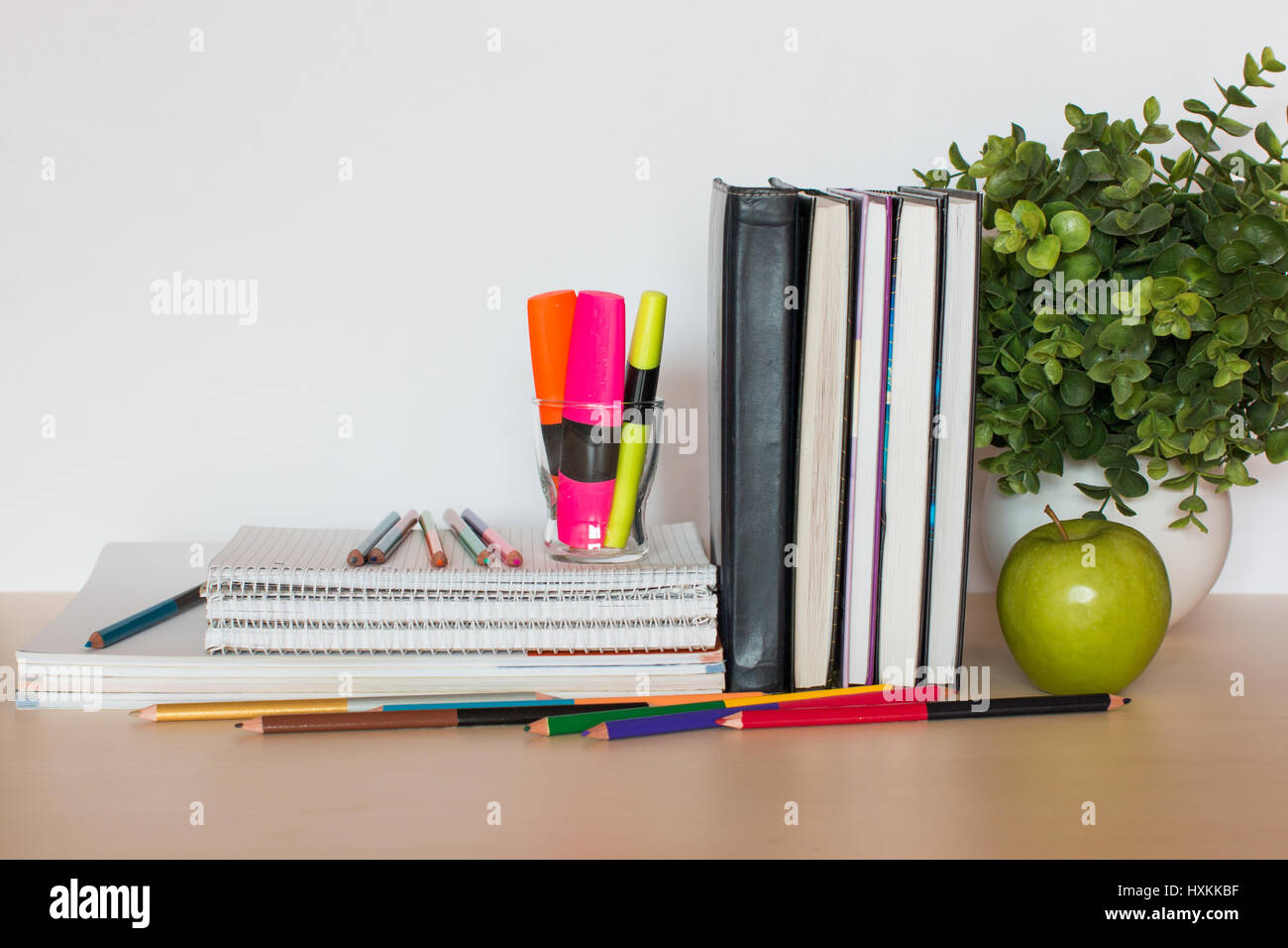 Back to school supplies. Books, pencils, notebooks and green apple ...