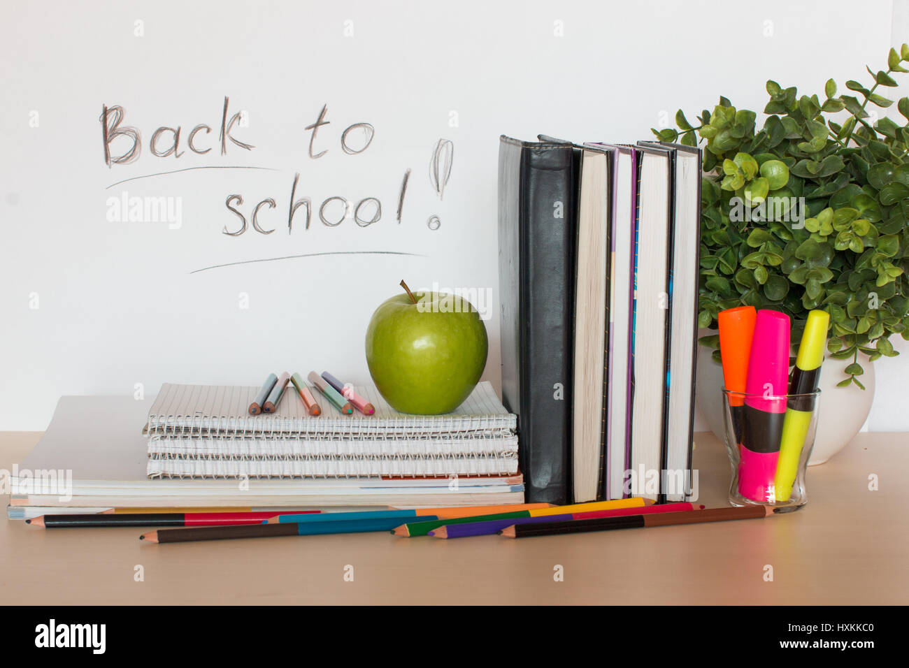 Back to school supplies. Books, pencils, notebooks and green apple ...