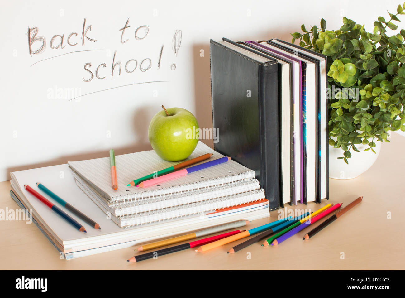 Back to school supplies. Books, pencils, notebooks and green apple ...